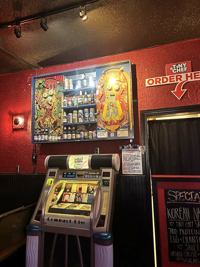 Part bar decor, part functional jukebox, part shrine to pinball artistry—where your bourbon sits below backglass that once entertained a generation.