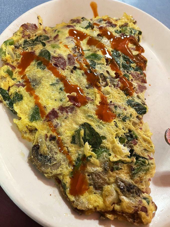 This omelet is having an identity crisis, thinking it's a garden with all those vegetables&mdash;but the hot sauce brings it back to diner reality.