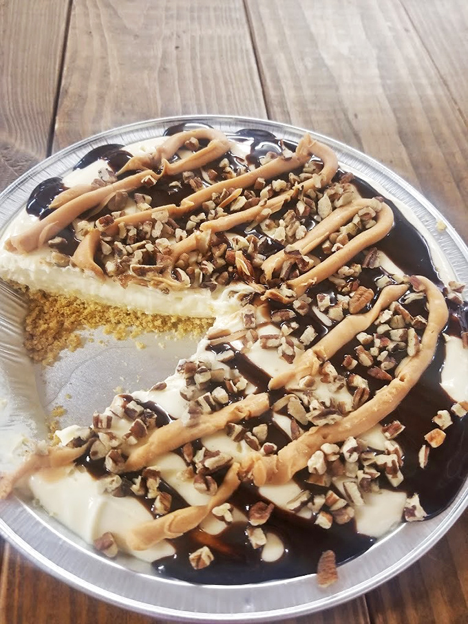 This peanut butter pie isn't messing around. The chocolate drizzle and nuts are just showing off at this point.