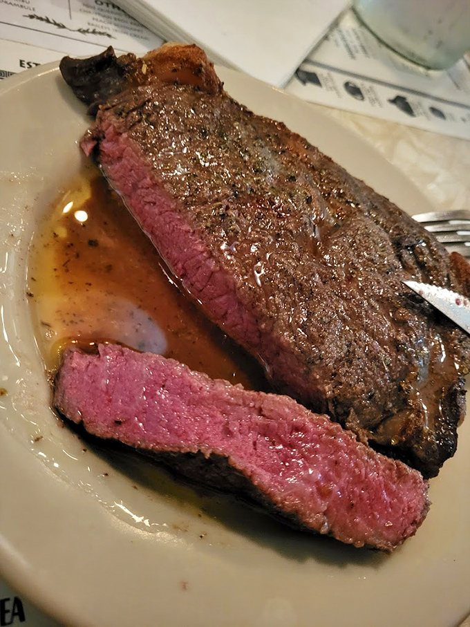 A perfectly cooked ribeye that makes you understand why people drive hours for dinner. That pink center against the caramelized crust is beef poetry.