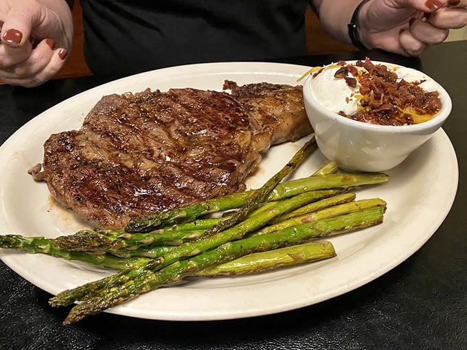 Golden onion rings and a perfectly seared steak create the kind of plate that makes conversation stop mid-sentence. Food worth the silence.
