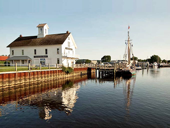 The Connecticut River Museum stands ready to receive visitors and vessels alike, its weathered dock extending like a handshake to maritime history.