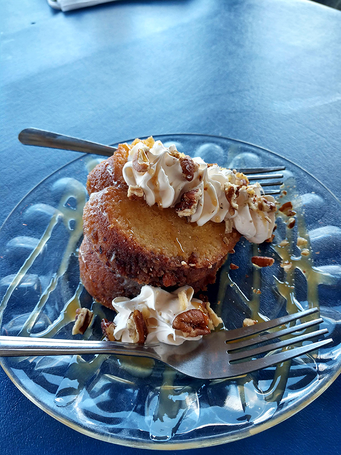 This rum cake isn't just dessert&mdash;it's an event, with whipped cream, pecans, and caramel creating a sweet symphony on a glass plate.