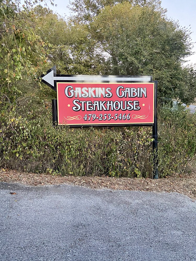 The roadside sign stands like a treasure map marker—easy to miss if you're not looking, impossible to forget once you've found it.