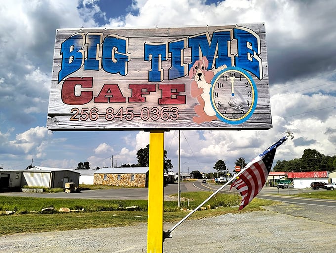 The roadside sign stands like a beacon of hope for hungry travelers, complete with patriotic flair and that adorable pup.