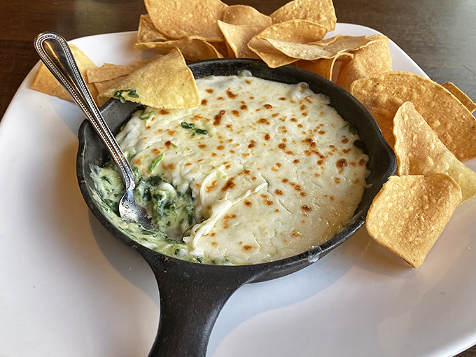 This isn't just spinach dip—it's a bubbling cauldron of cheese-meets-vegetable sorcery that turns tortilla chips into treasure-hunting tools.