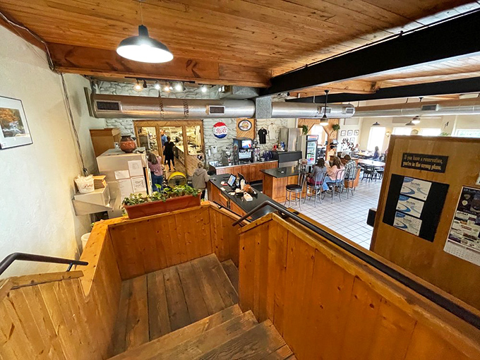 The wooden staircase reveals the restaurant's multi-level charm, inviting you deeper into this pizza sanctuary tucked in the mountains.