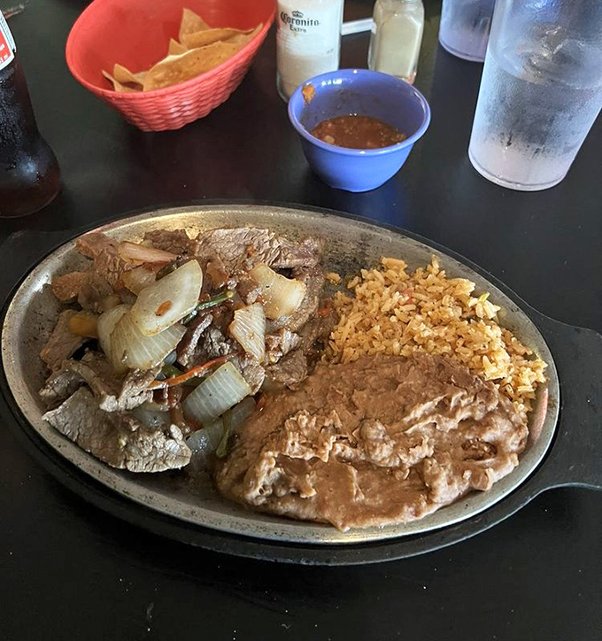 Sizzling steak strips with caramelized onions—a plate that announces its arrival with both aroma and sound.