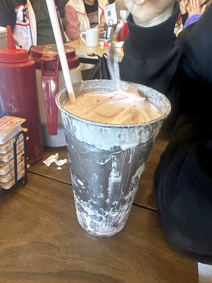 That's not just a strawberry shake—it's a frosty aluminum vessel of nostalgia so thick you'll need that straw's full commitment to enjoy it.