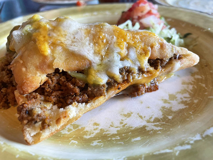 Meet the stuffed sopapilla – where flaky pastry embraces savory fillings before taking a luxurious bath in melted cheese.