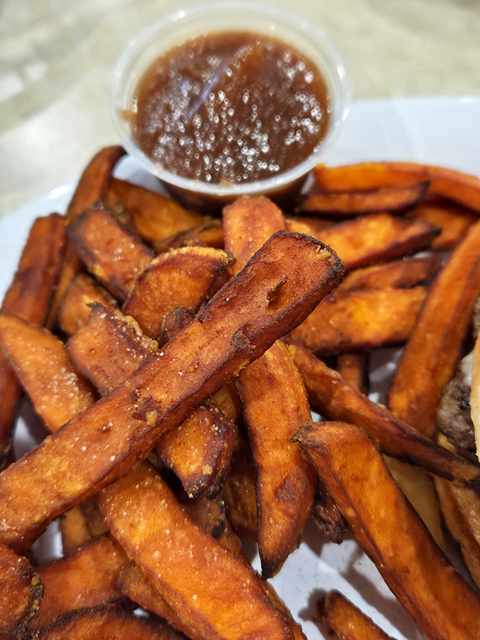 Sweet potato fries with a caramelized exterior and pillowy interior, paired with a dipping sauce that elevates them from side dish to main event.