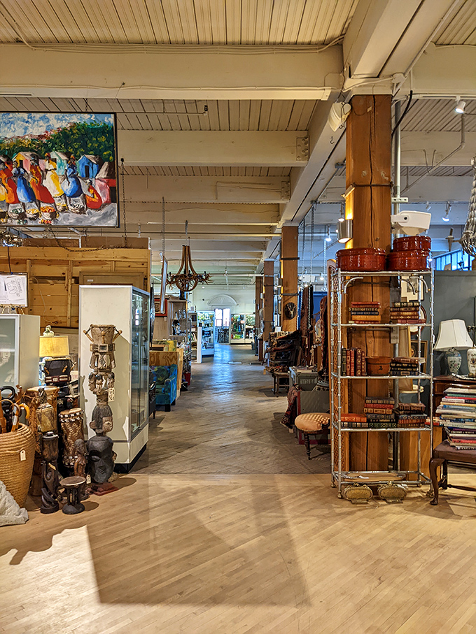 The architectural bones of this former factory create perfect pathways between worlds, where African masks neighbor vintage books and mid-century furniture.