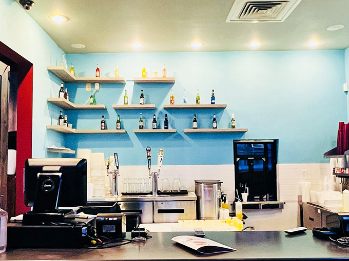 The aqua blue wall with its bottle display adds a splash of coastal charm. It's like they bottled the ocean vibe and brought it to Arkansas.