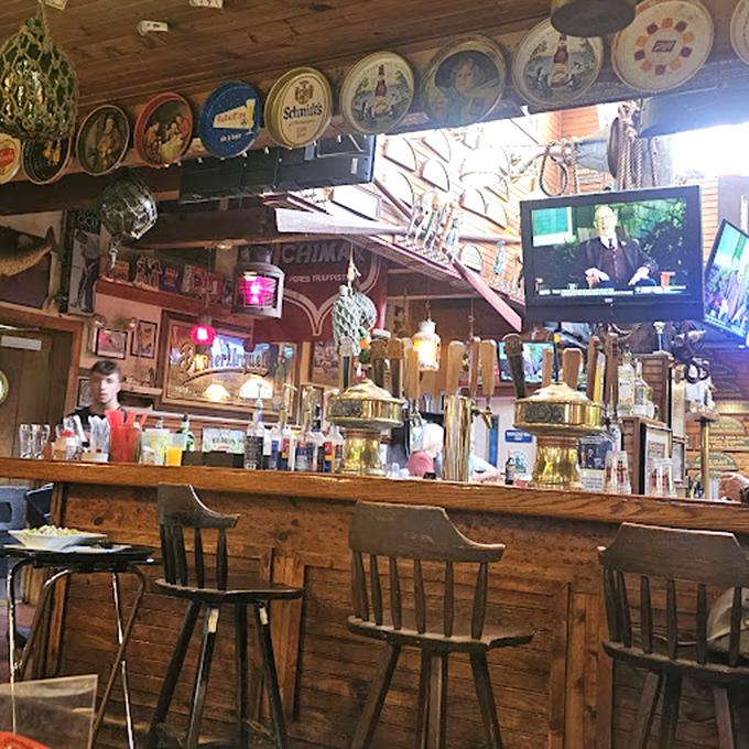 The bar isn't just where drinks are served—it's where stories are exchanged beneath vintage beer trays and the warm glow of nostalgia.