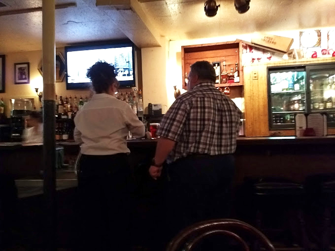 The bar area whispers of Prohibition days with vintage signs, where modern cocktails meet historical ambiance in perfect harmony.