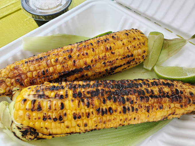 Elote &ndash; grilled corn elevated to art form. Those char marks aren't accidents; they're flavor autographs signed with fire and finished with lime.
