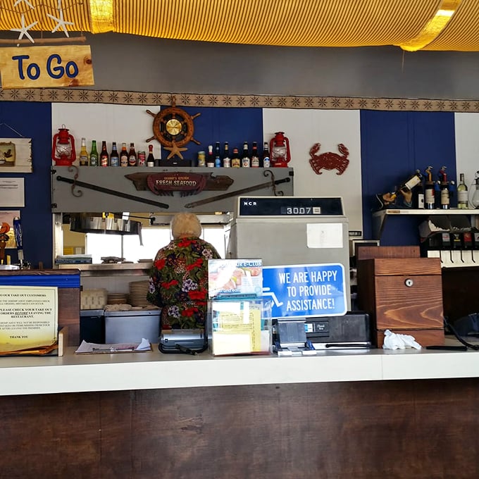 Behind the counter, where seafood magic happens. The "To Go" sign tempts you to bring the ocean's bounty home, but why wait?