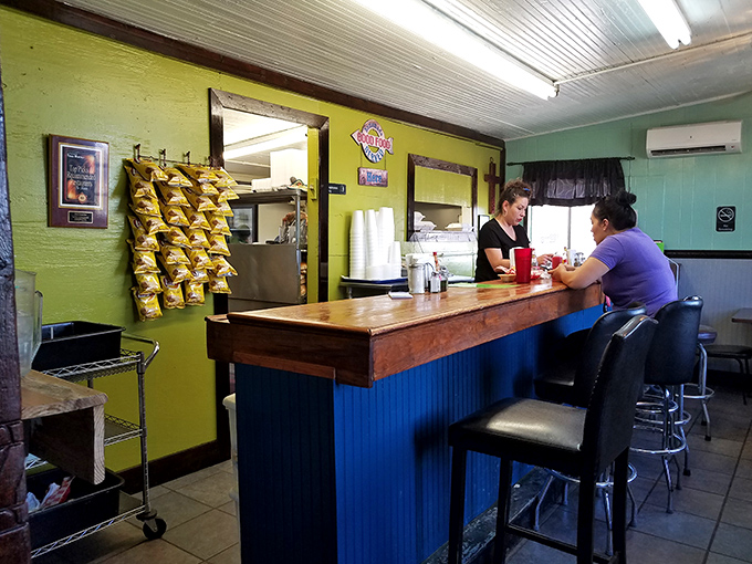 The blue counter where transactions are simple: you give money, they give happiness. The chips rack stands guard like a salty sentinel.