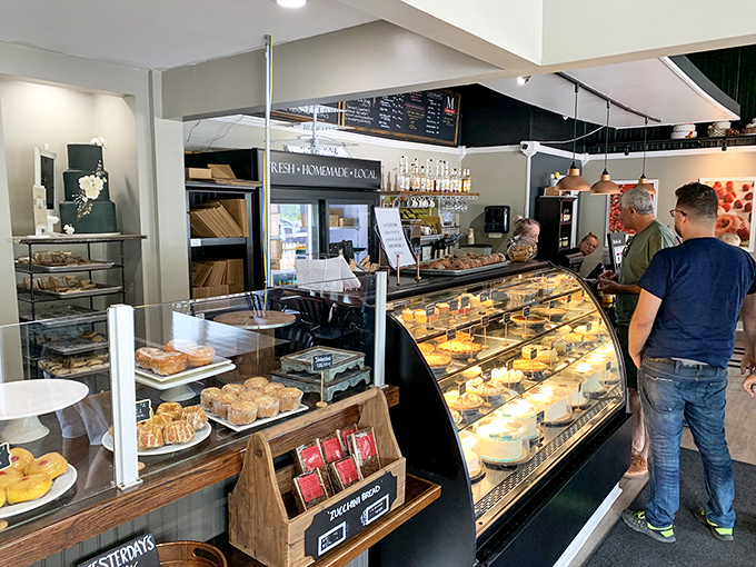Where pastry pilgrims gather to worship at the altar of butter and sugar. The glass case serves as both barrier and window to temptation.