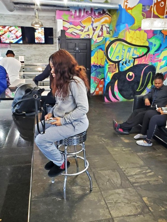 Customers patiently waiting for seafood treasures while surrounded by vibrant art. The calm before the delicious storm.