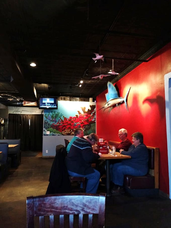 Diners enjoying the warm glow of Shucks' red walls and nautical decor, proving that seafood brings people together even in the heart of beef country.