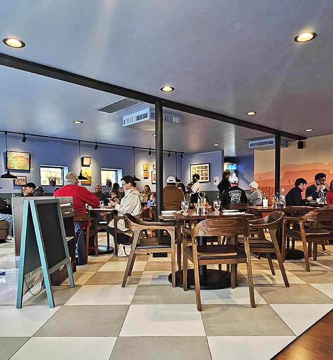 A bustling dining room where strangers become temporary neighbors, united by the universal language of "pass the hot sauce, please."