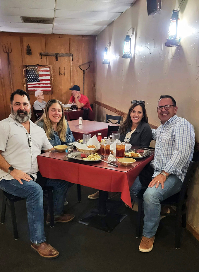 Happy diners gathered around a red-clothed table, surrounded by lantern light and American flags. This is what "breaking bread together" looks like in the heartland.