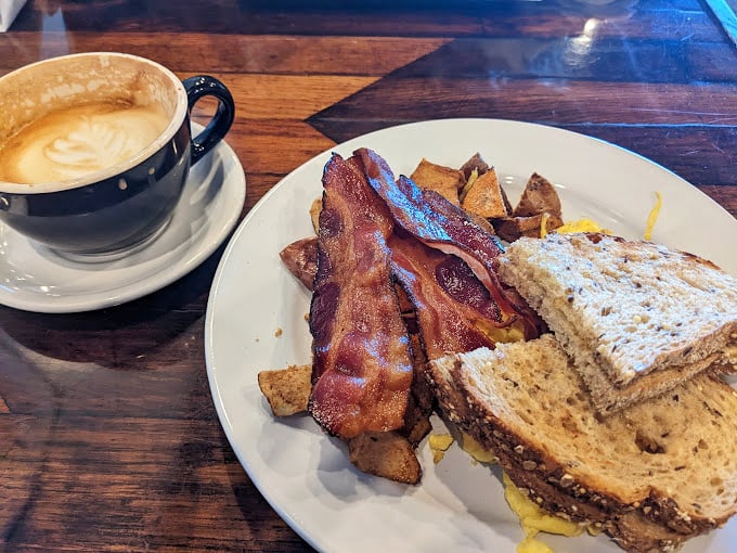 A breakfast sandwich that understands the importance of proper bacon-to-bread ratio. Paired with coffee that makes Monday mornings almost bearable.