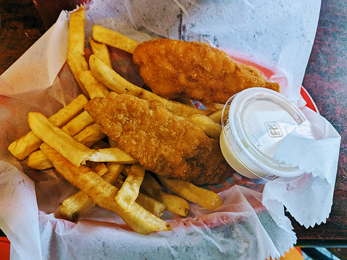 Fish and chips that would make a British pub jealous, wrapped in paper that soon bears the hallmarks of a delicious surrender.