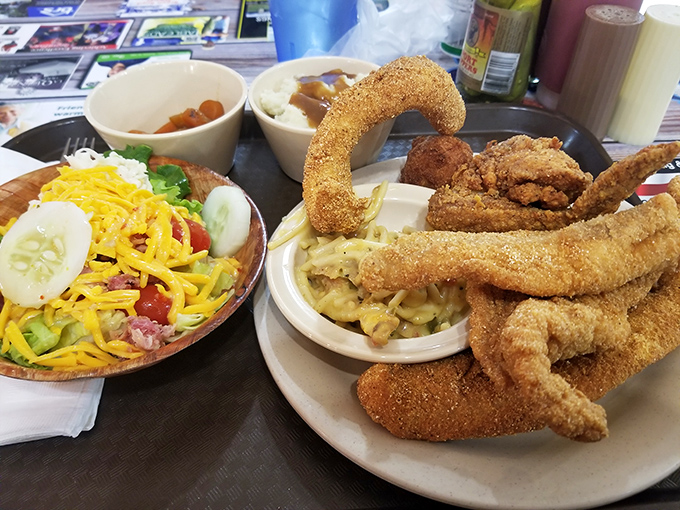 Catfish fillets curved like smiles, perched atop a bed of sides that turn an ordinary lunch into a celebration of Arkansas abundance.