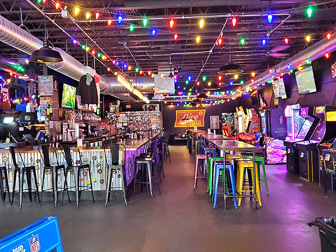 Edison bulbs illuminate the impressive bar where mixology meets gaming culture under a canopy of multicolored string lights.