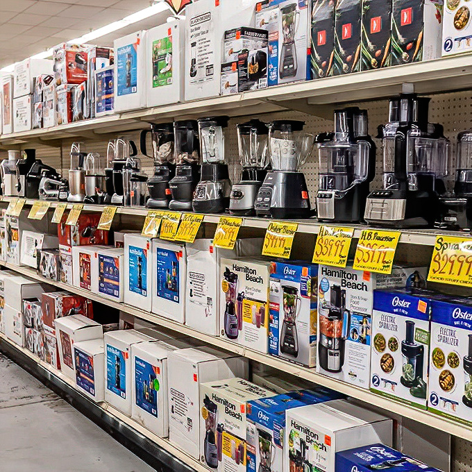Brand-name blenders and food processors line the shelves, their yellow clearance tags announcing their fall from retail grace and into your shopping cart.