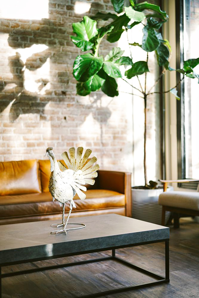 The lounge area combines leather, brick, and whimsical metal art in a way that says, "Stay awhile, we've got mac and cheese coming."