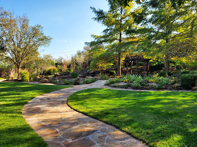 This serene garden path invites contemplative strolls through thoughtfully landscaped greenery, a perfect counterpoint to Guthrie's brick-and-mortar main streets.