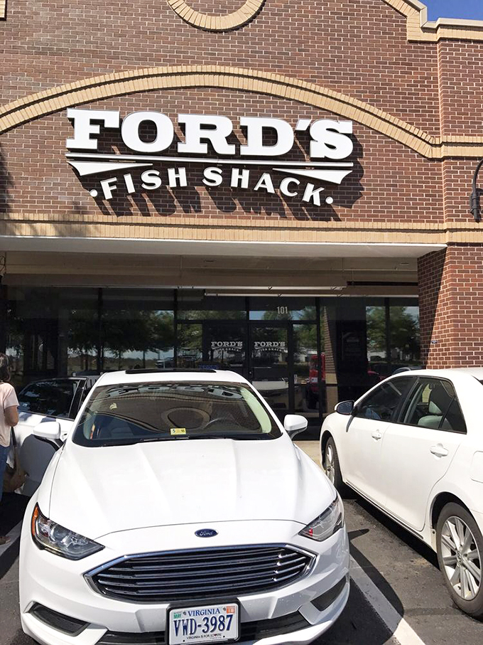 The sign promises seafood salvation in bold letters, while Virginia license plates below remind you this maritime miracle happens in landlocked Ashburn.
