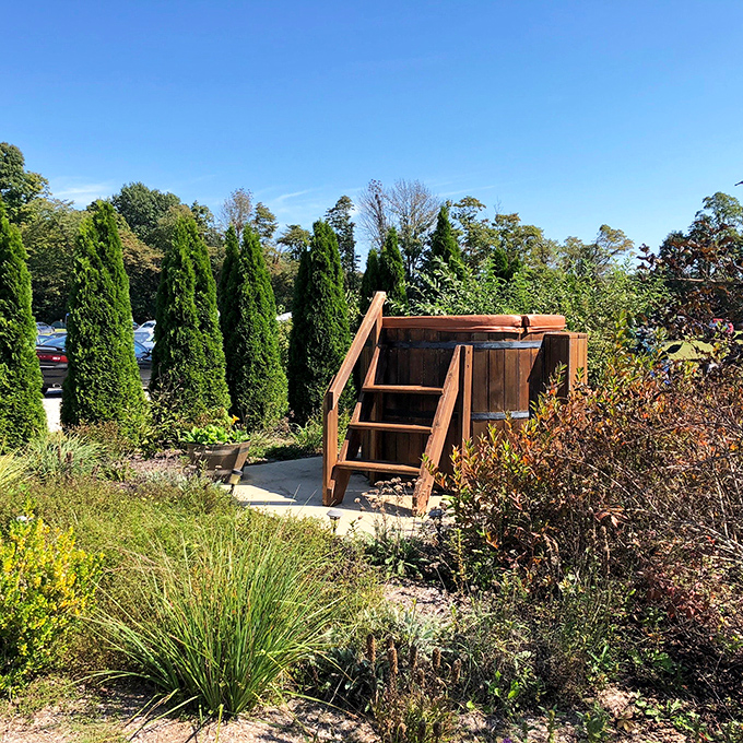 Not your average backyard feature, this wooden hot tub surrounded by greenery offers medieval-inspired relaxation with a view of the grounds.