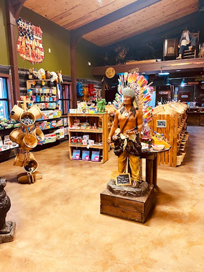 A life-sized Native American statue stands sentinel among candy displays and souvenir shelves. The wooden floors and rustic decor blend frontier aesthetics with modern retail.