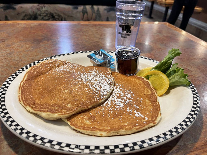 Pancakes so perfectly round and golden they look like they were traced with a compass. The powdered sugar snowfall is just showing off.