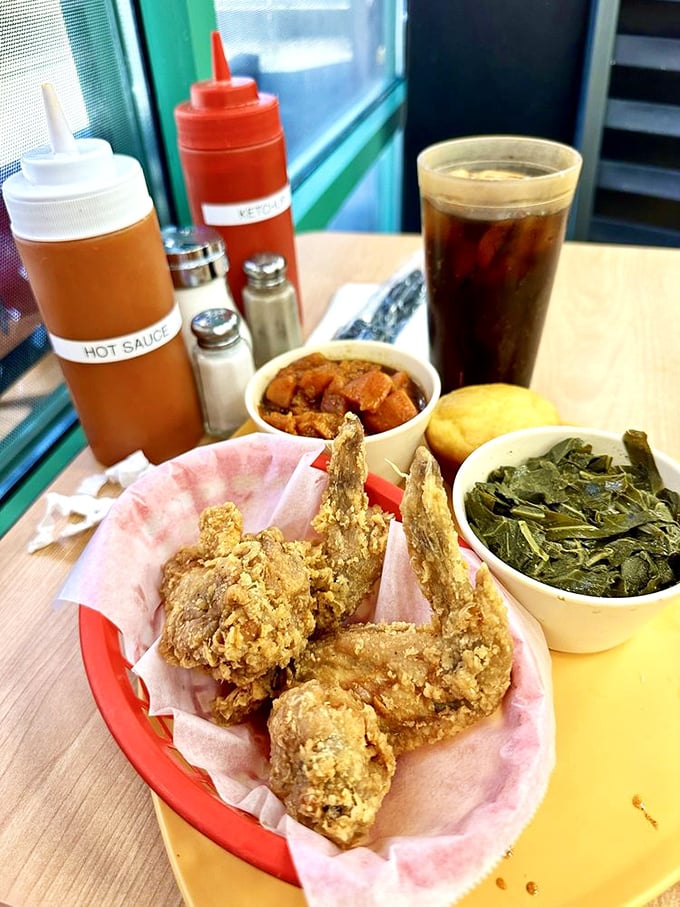 Fried chicken wings nestled beside collard greens and cornbread&mdash;a plate that proves vegetables can still be exciting with the right company.