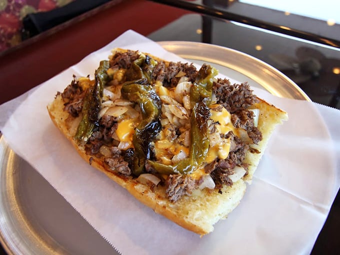 A cheesesteak revelation on a metal tray&mdash;where thinly sliced beef, caramelized vegetables, and melted cheese achieve sandwich harmony.