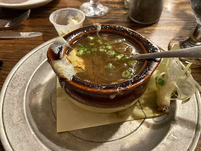 French onion soup that's wearing its cheese beret with pride. This isn't just comfort food&mdash;it's a warm hug in a crock that's survived more winters than most countries.