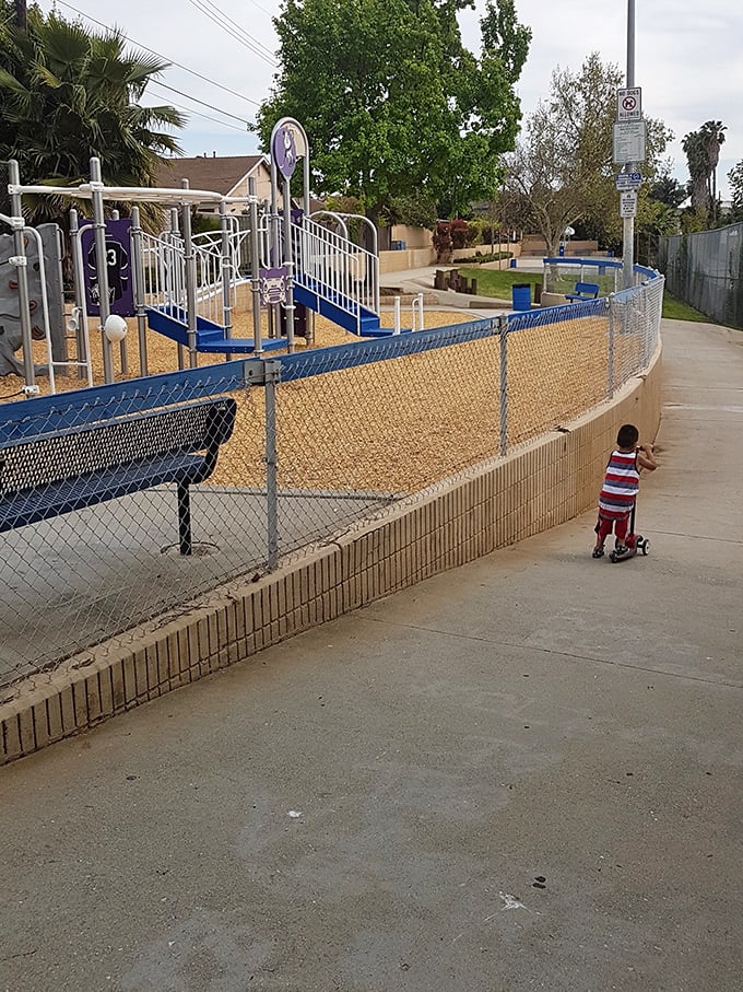 This playground's white fence isn't just a boundary &ndash; it's an invitation to childhood adventures that don't require a screen or charging cable.