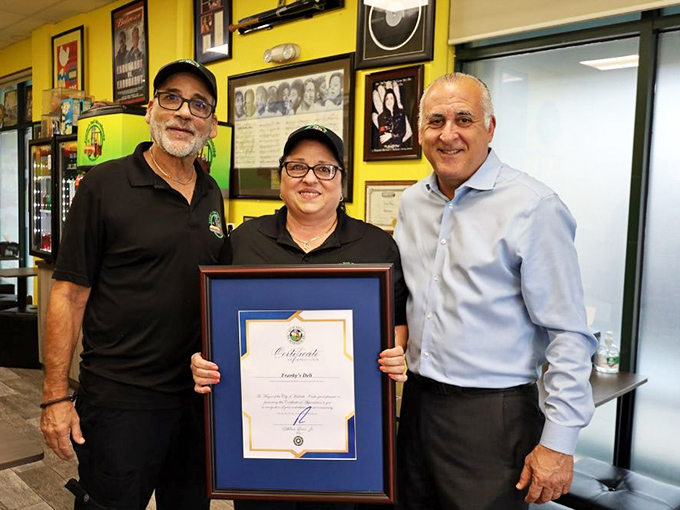 Proud owners displaying their well-earned recognition. Behind every great sandwich is a team that cares about quality.