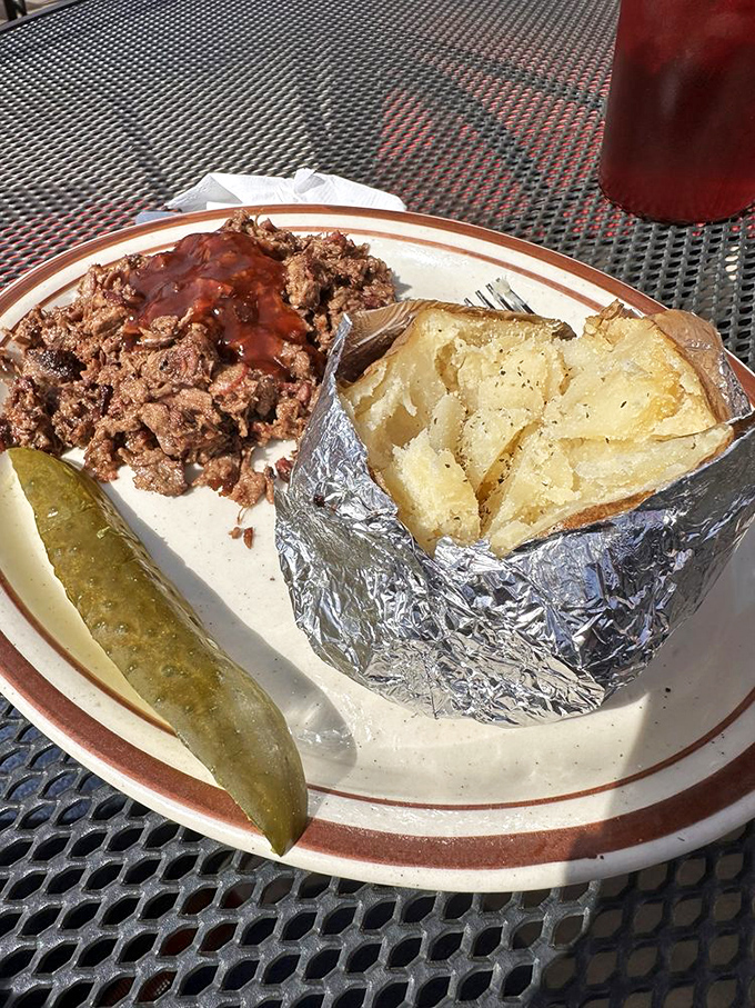 Pulled pork with sauce and a foil-wrapped potato that's been through some things. This plate understands the meaning of "simple pleasures."