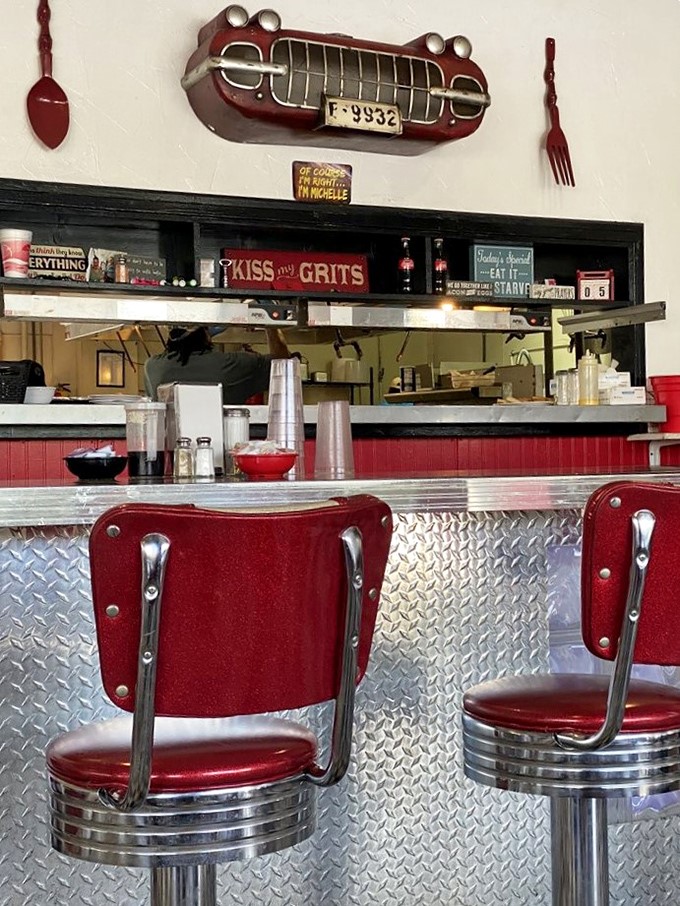 The counter view with its "Kiss My Grits" sign tells you everything about the establishment's delightful sense of humor.