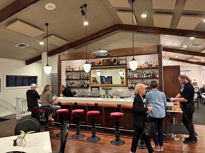 The bar beckons with its handsome wooden counter and red-topped stools &ndash; the perfect perch for solo diners or those waiting for a table. Photo credit: Tommy Dowd