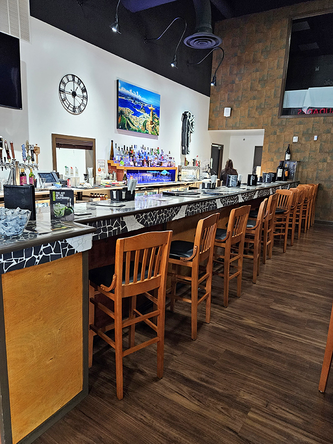 The bar stretches like a runway where cocktails take flight. That distinctive black and white pattern says, "Serious drinking happens here."