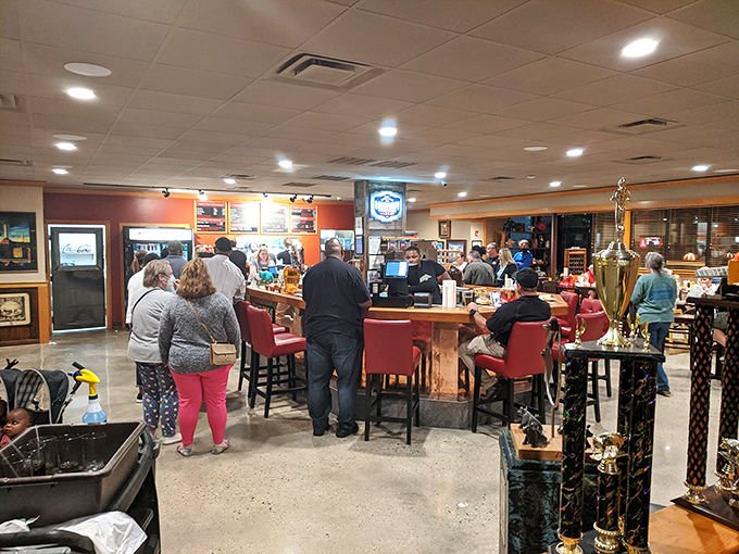 The bustling counter area where barbecue pilgrims place their orders, surrounded by the trophies that validate their journey.