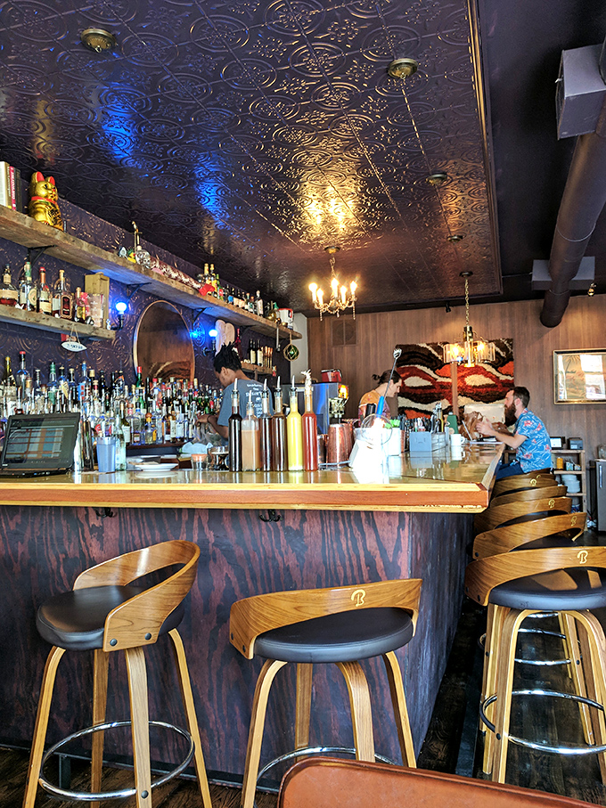 The bar's ornate ceiling watches over cocktail magic below &ndash; where Southern spirits meet in glasses rather than haunting old mansions.