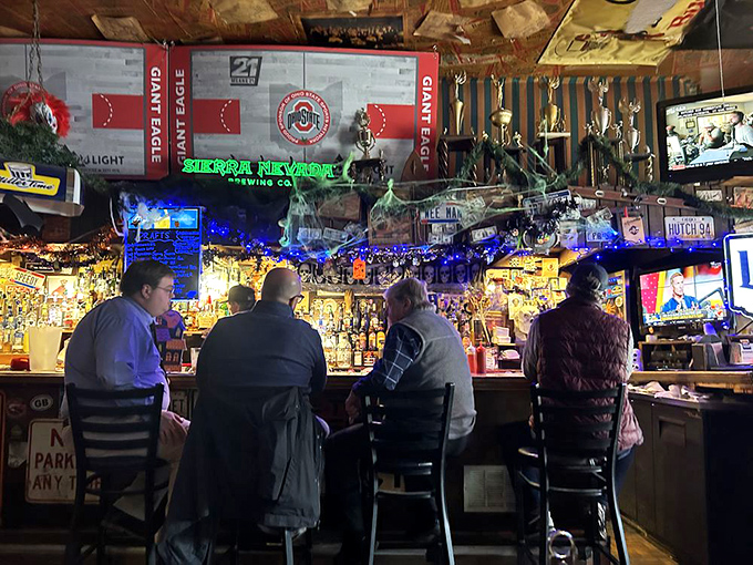 The bar area glows with neon signs and Ohio State memorabilia, where strangers become friends over shared burger war stories.